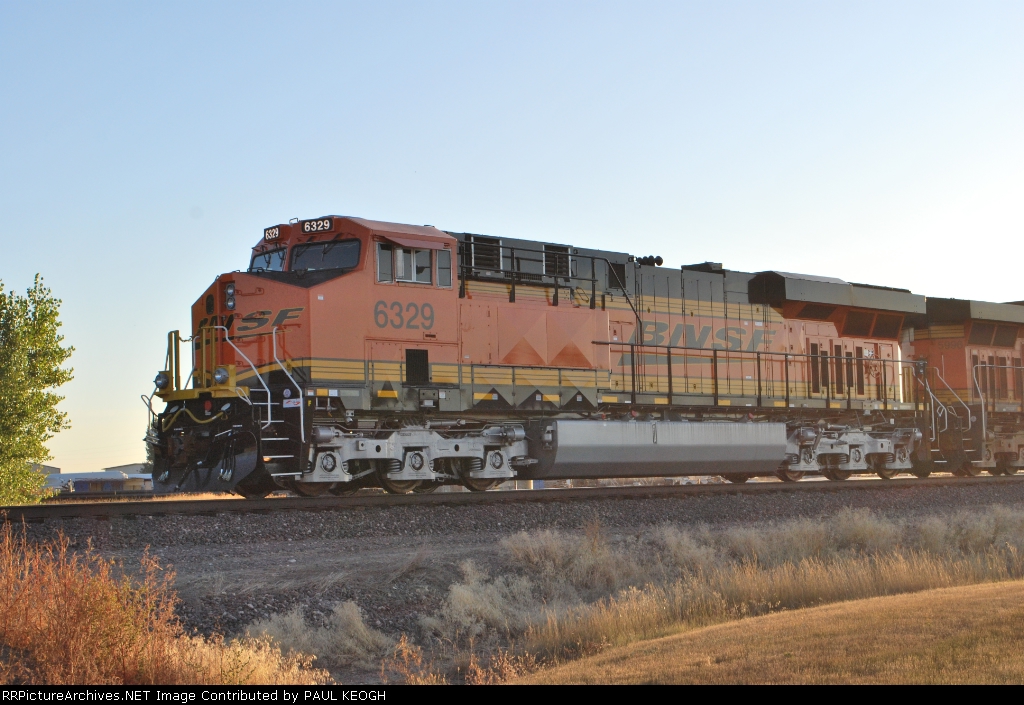 BNSF 6329 and BNSF 5990 wait to roll west as the sun starts to rise behind them. BNSF 6327 is ...